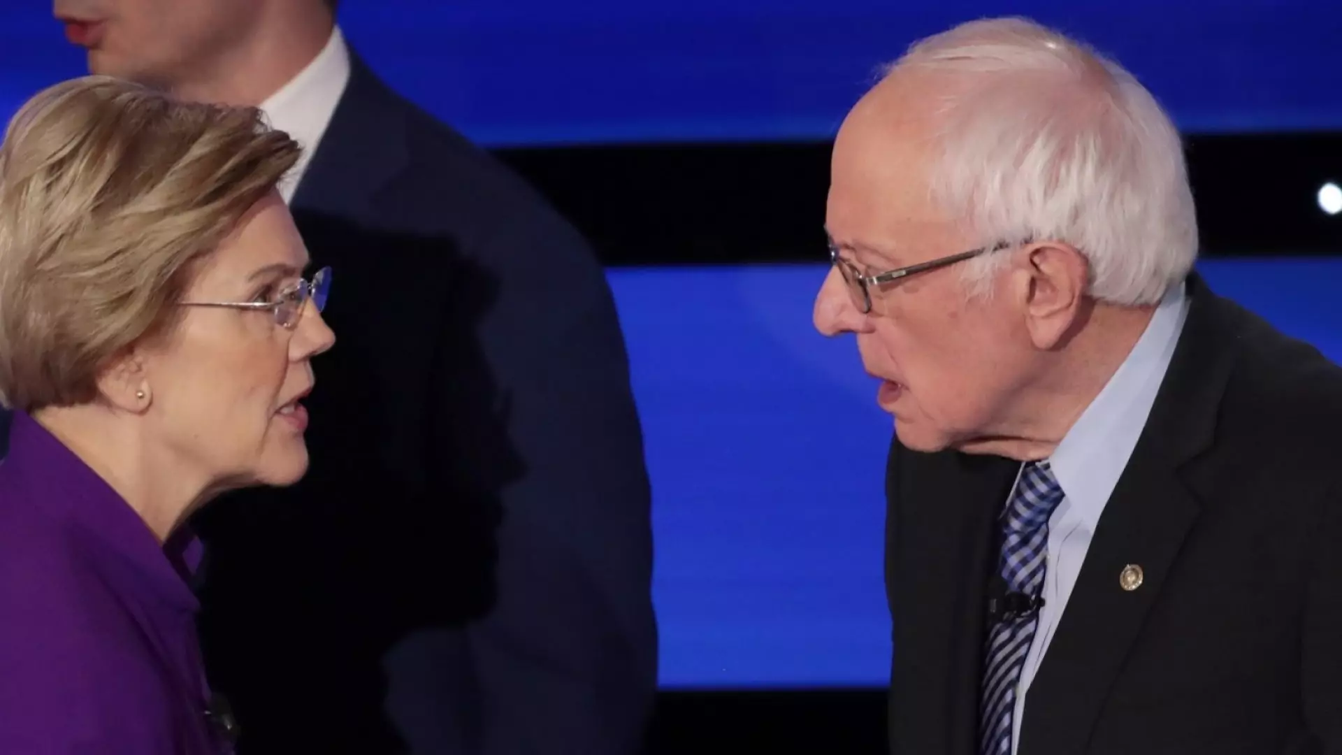 Elizabeth Warren e Bernie Sanders conversando após o debate de terça-feira em Iowa.