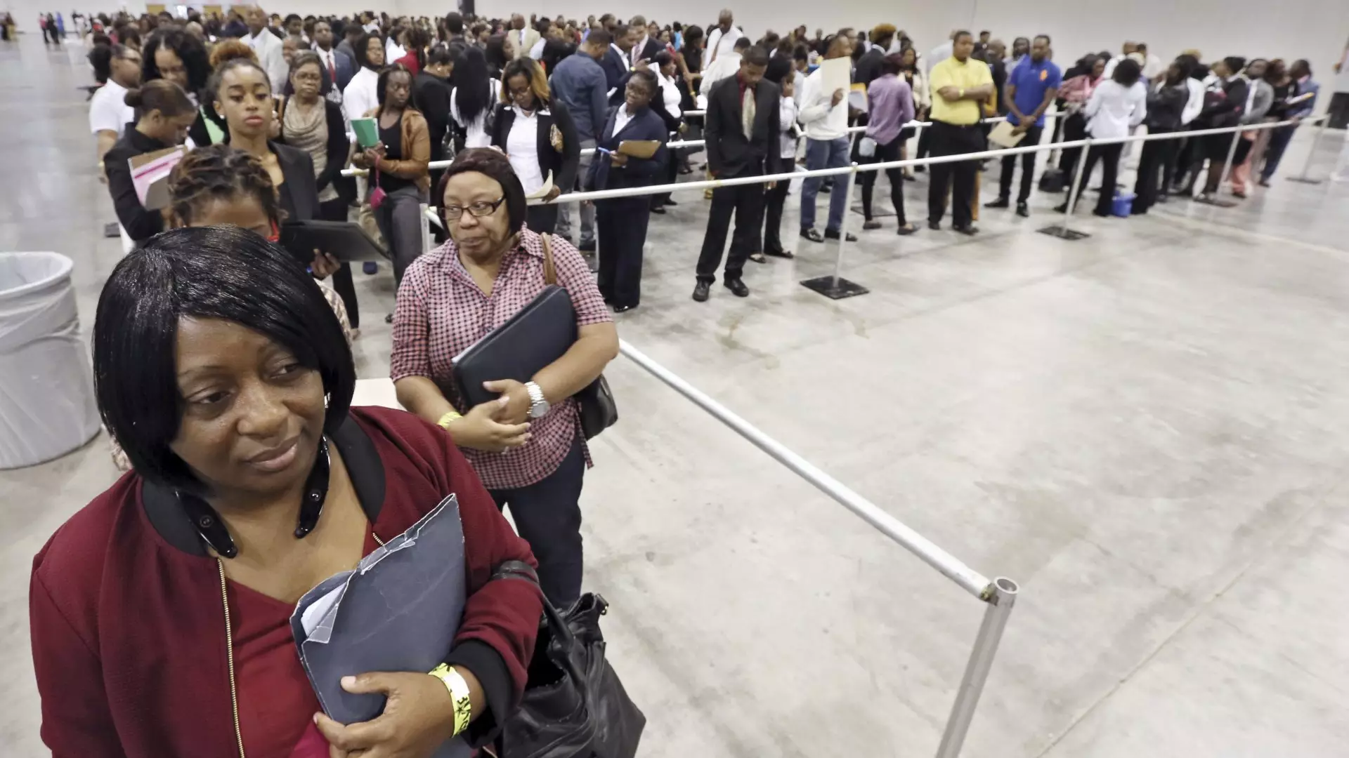 Kanockwa Horton, á esquerda, de Stone Mountain, e Jacqueline Merritt, de Atlanta, son as primeiras da fila na Airport Community Job Fair, en Atlanta, xunto con centos de candidatos máis en fila antes da inauguración das 10 da mañá.