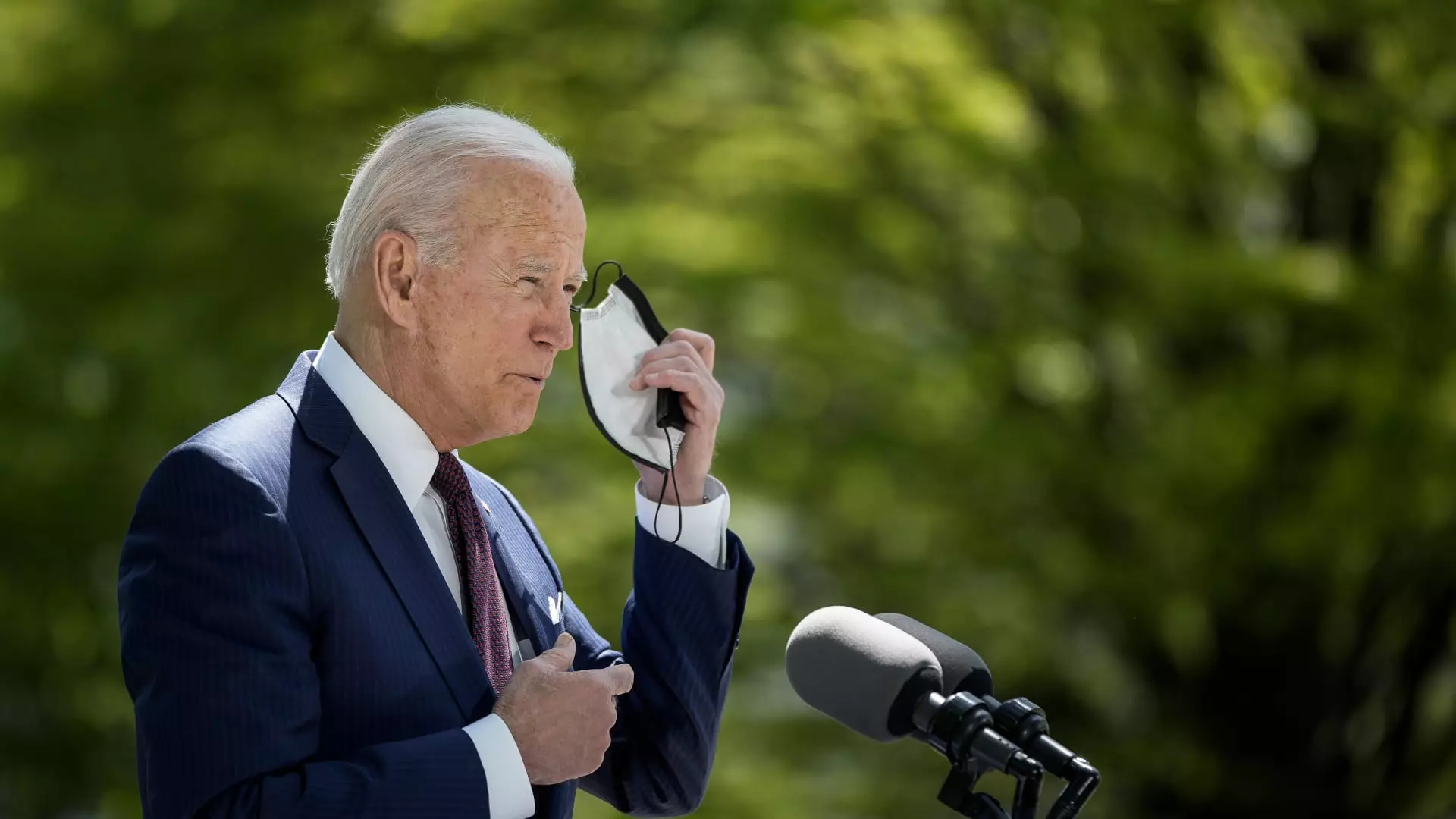 Presidenti Joe Biden heq maskën e tij përpara se të flasë për udhëzimet e përditësuara të maskave të CDC në lëndinë veriore të Shtëpisë së Bardhë më 27 Prill 2021, në Uashington, D.C. Presidenti Biden njoftoi udhëzimet e përditësuara të CDC, duke thënë se amerikanët e vaksinuar nuk kanë nevojë të mbajnë maskë jashtë kur në grupe të vogla.